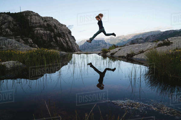 Side view of a woman jumping over water - Royalty-free Stock Photo ...