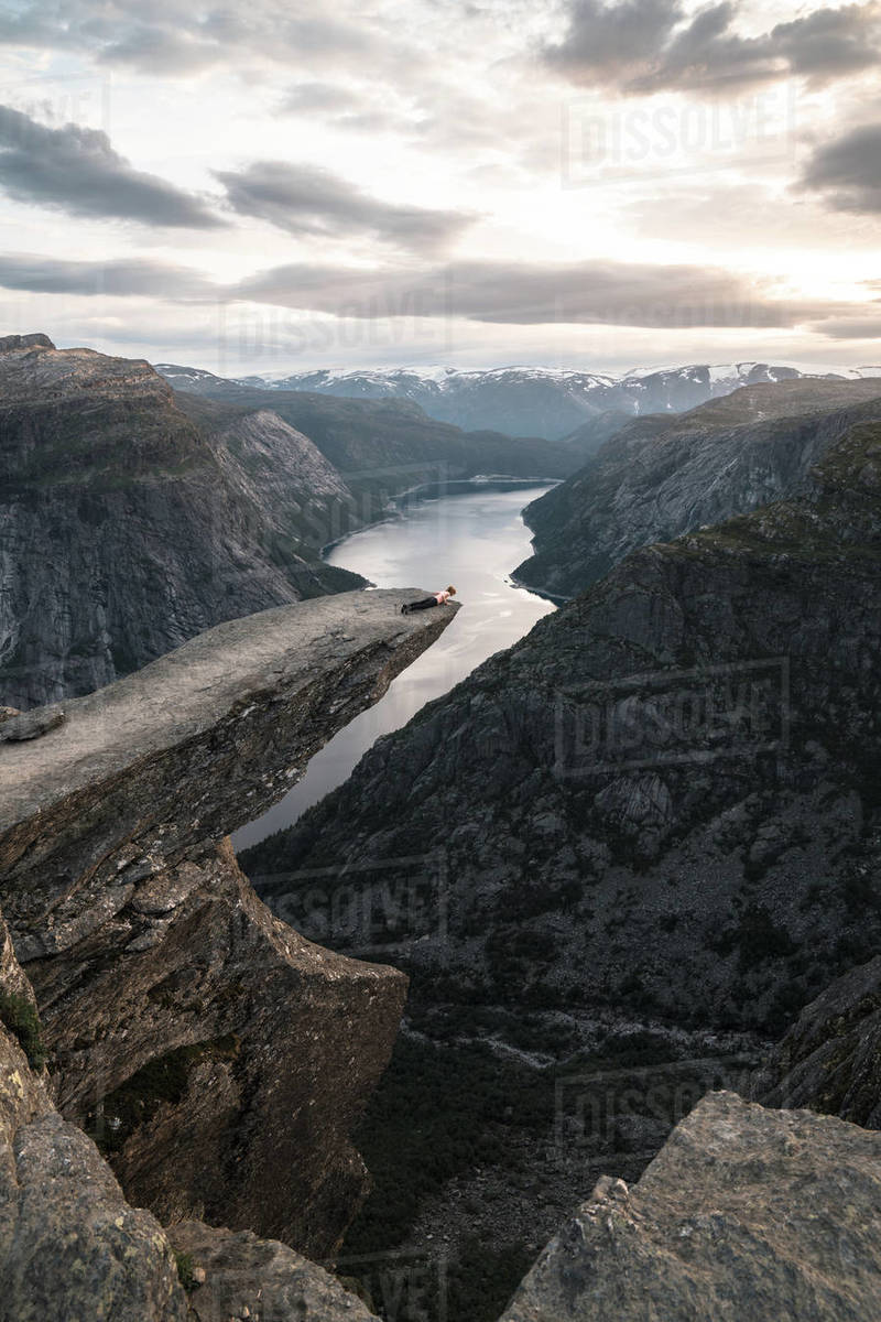 Woman lying on top of cliff - Royalty-free Stock Photo | Dissolve
