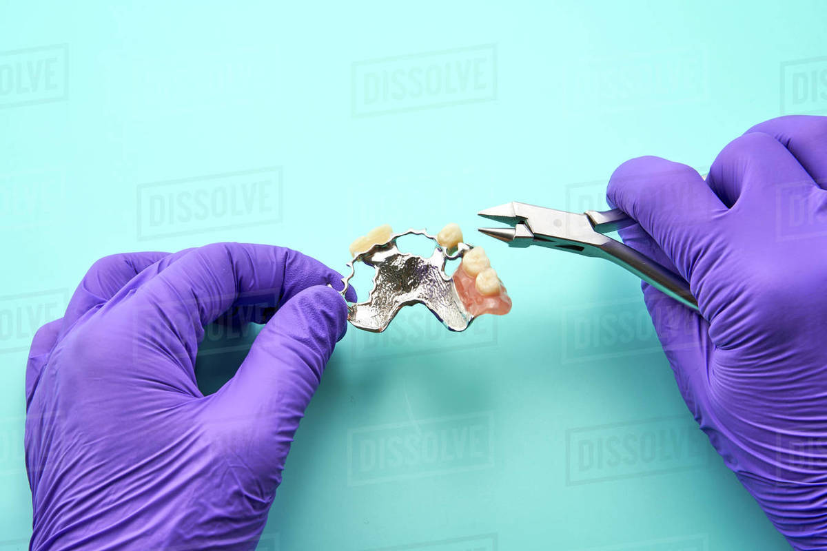 Dental technician making a denture, on a green workbench. - Stock Photo ...