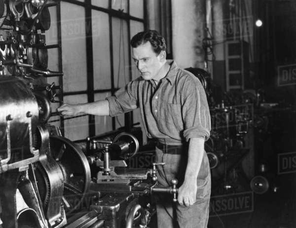 Serious man using large machine - Royalty-free Stock Photo | Dissolve