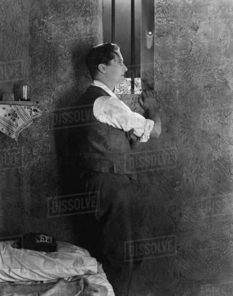 Man at window of prison cell - Royalty-free Stock Photo | Dissolve