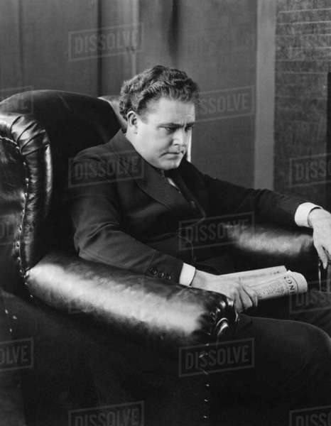 Portrait of brooding man in easy chair - Stock Photo - Dissolve