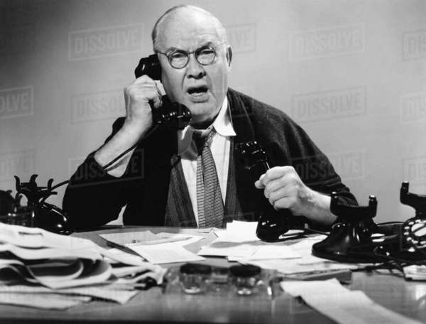 Businessman using multiple phones - Stock Photo - Dissolve