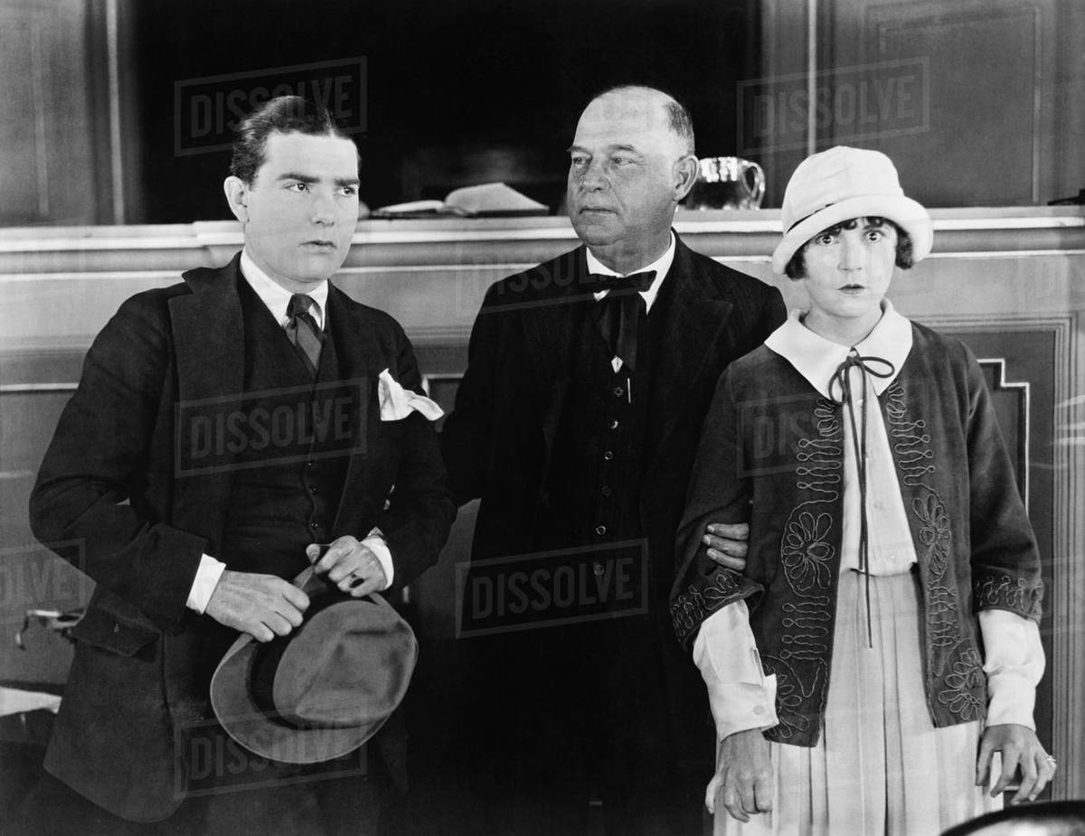 Three people standing together while one is holding on to the other two ...