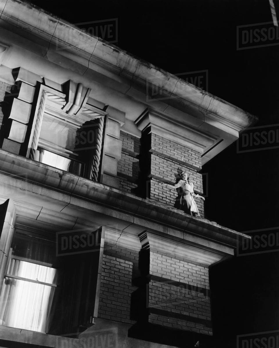 Woman standing on the top of a building on a ledge - Royalty-free Stock ...
