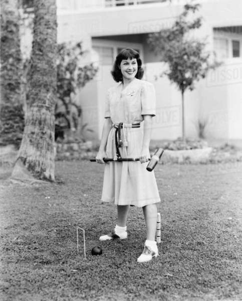 Woman playing croquet in the yard - Stock Photo - Dissolve