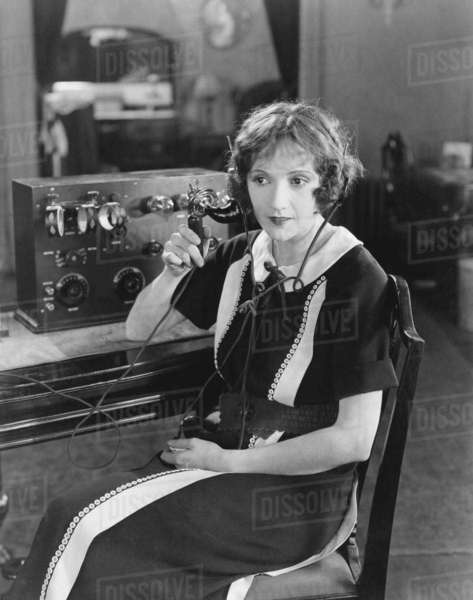 Switchboard operator sitting at telephone switchboard and talking ...