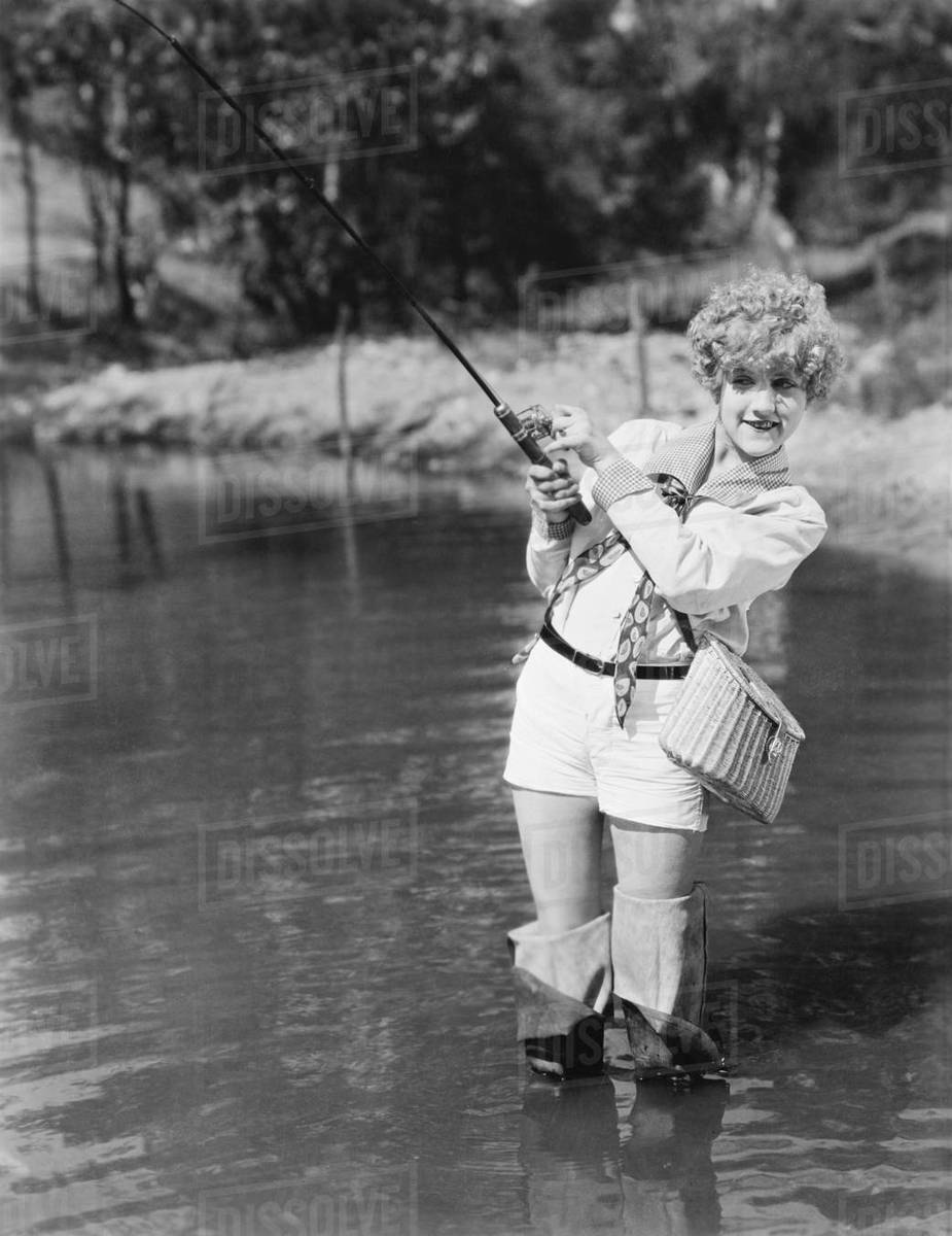 Young woman wearing waders holding a fishing rod - Royalty-free Stock ...