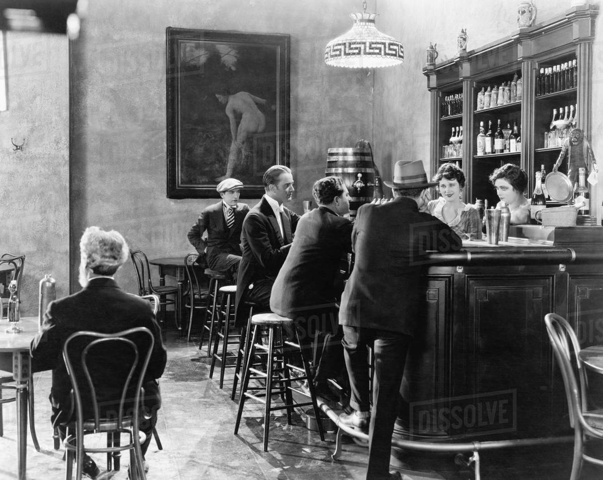 Men sitting around a counter in a bar - Royalty-free Stock Photo | Dissolve