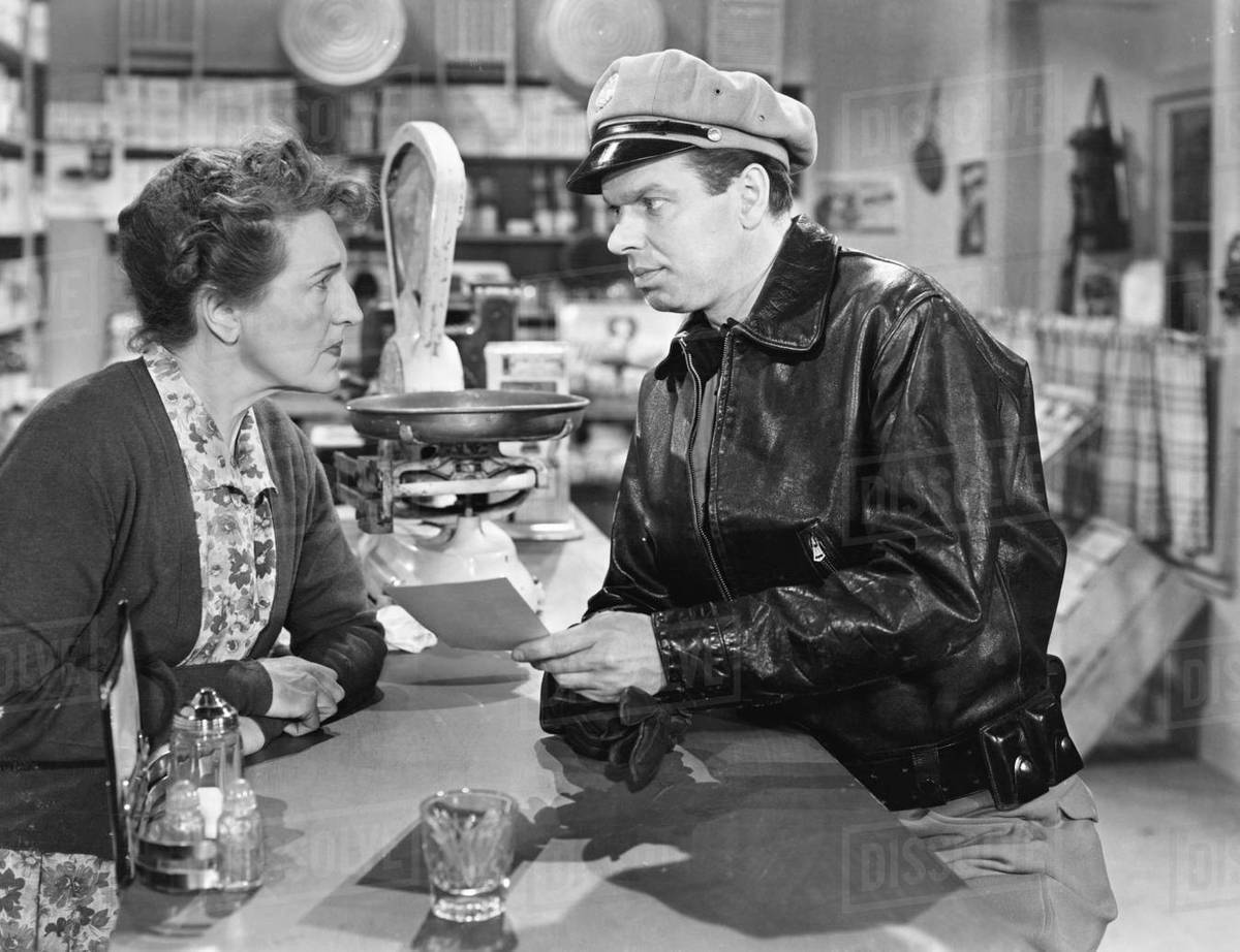 Policeman standing in at a counter in a general store - Royalty-free ...