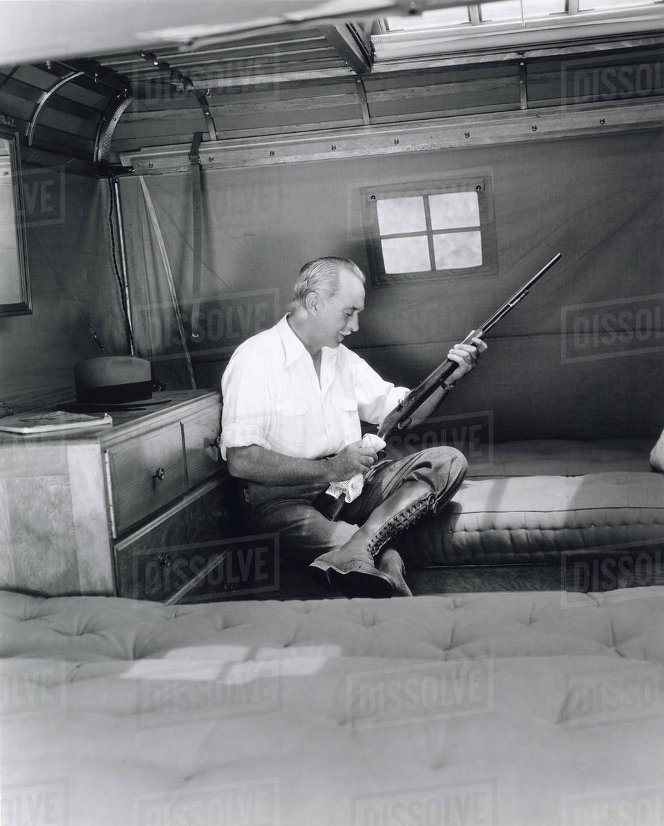 Man cleaning his rifle - Stock Photo - Dissolve
