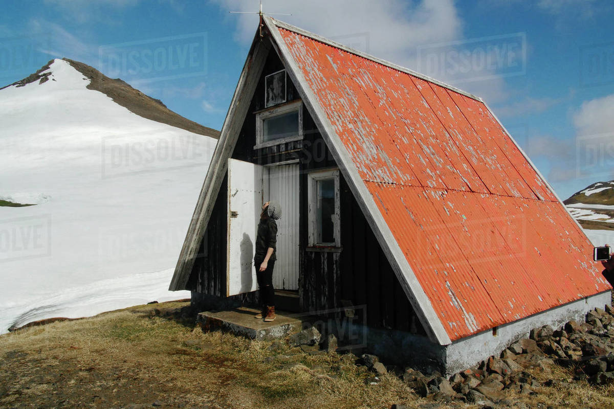 Man looking at hut in Iceland - Royalty-free Stock Photo | Dissolve