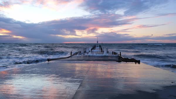 Static shot of powerful ocean waves protruding through boat jetty at ...