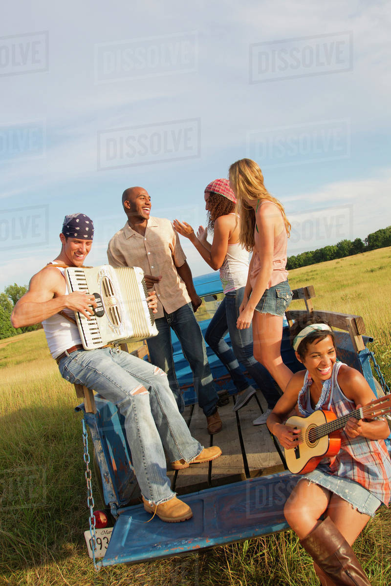 Friends playing musical instruments on back of truck - Royalty-free ...