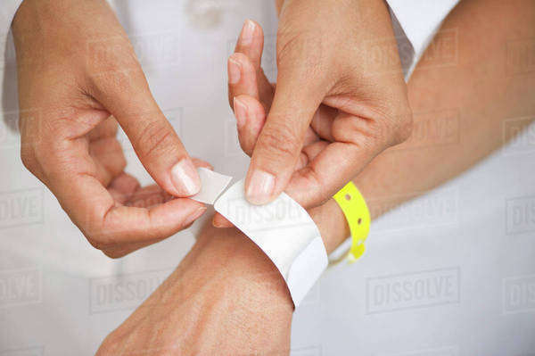 Nurse putting identification bracelet on patient in hospital - Royalty ...