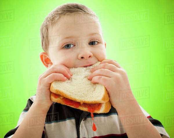 Caucasian boy eating peanut butter and jelly sandwich - Royalty-free ...