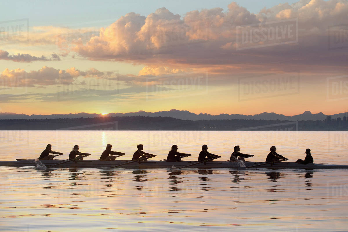 Team rowing boat in bay - Royalty-free Stock Photo | Dissolve
