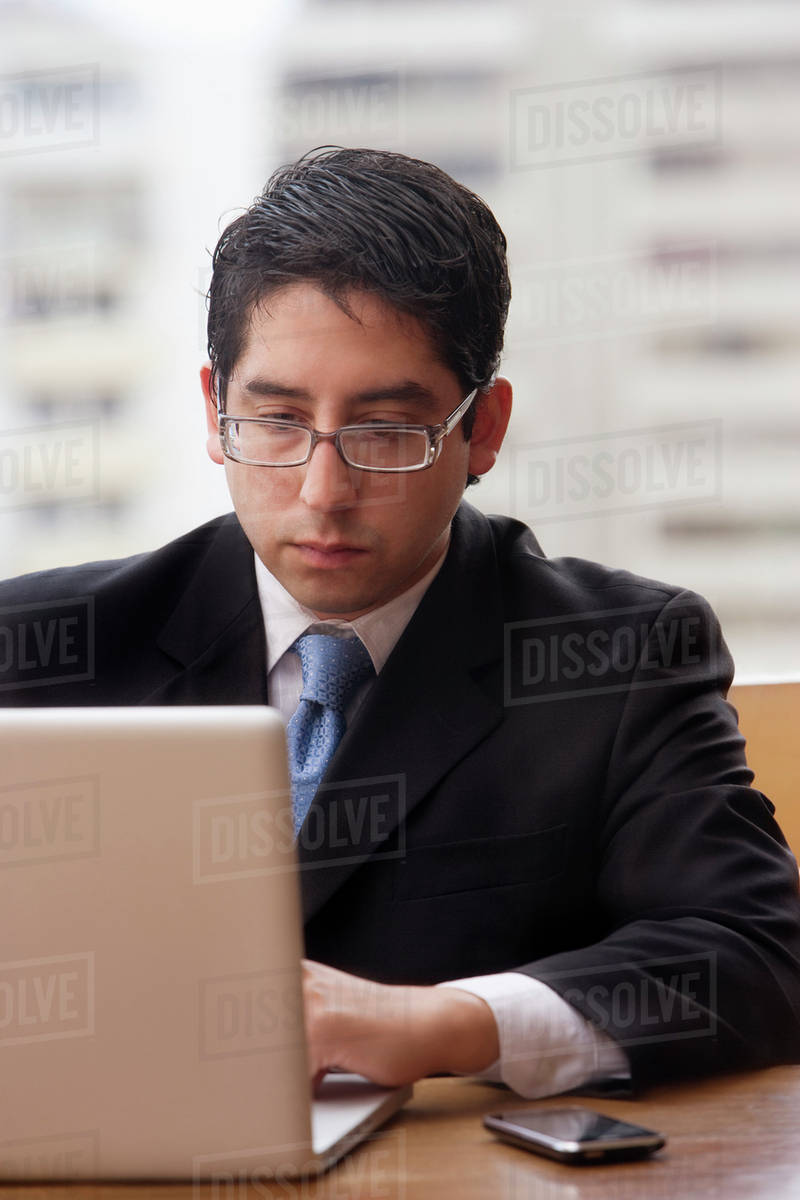 Chilean businessman using laptop - Stock Photo - Dissolve
