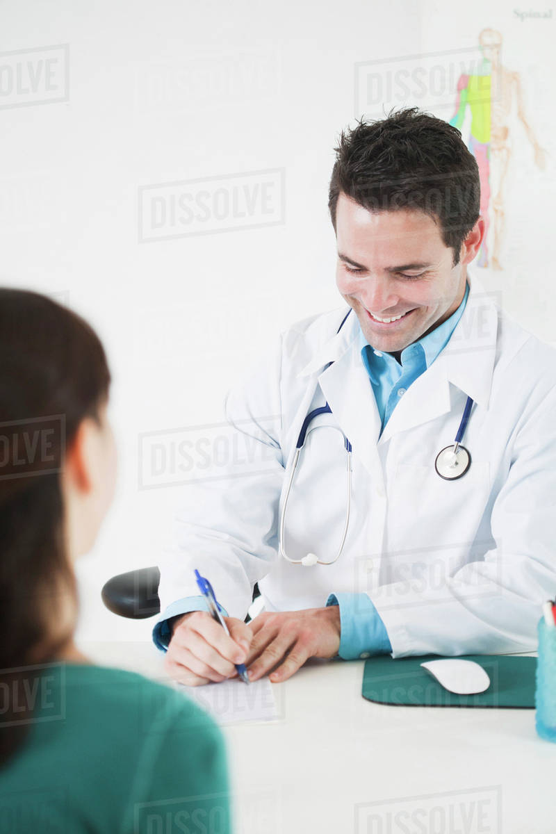 Doctor sitting at desk with patient - Royalty-free Stock Photo | Dissolve