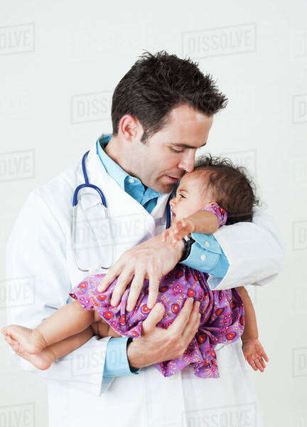 Doctor comforting baby girl - Royalty-free Stock Photo | Dissolve