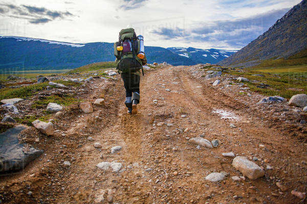 Mari backpacker walking on dirt path - Royalty-free Stock Photo | Dissolve