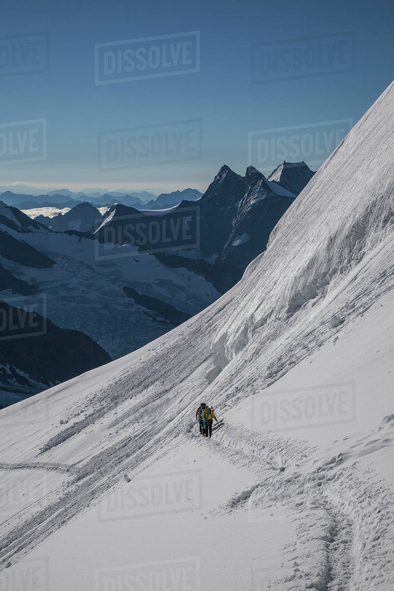 Hiker on snowy mountain slopes - Stock Photo - Dissolve