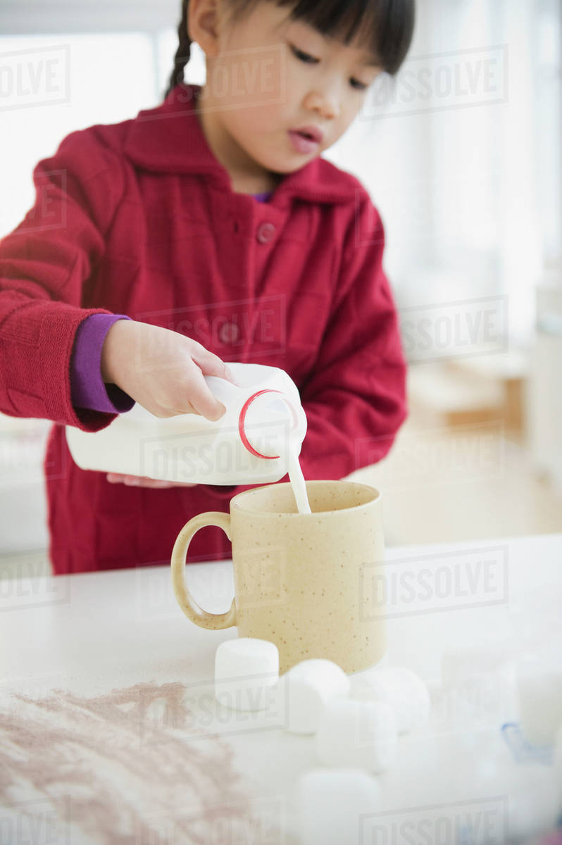 Chinese girl making hot chocolate - Stock Photo - Dissolve