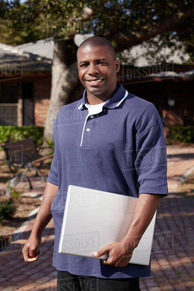 Black man carrying laptop - Royalty-free Stock Photo | Dissolve