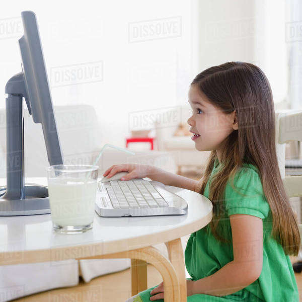 Mixed race girl using computer - Royalty-free Stock Photo | Dissolve