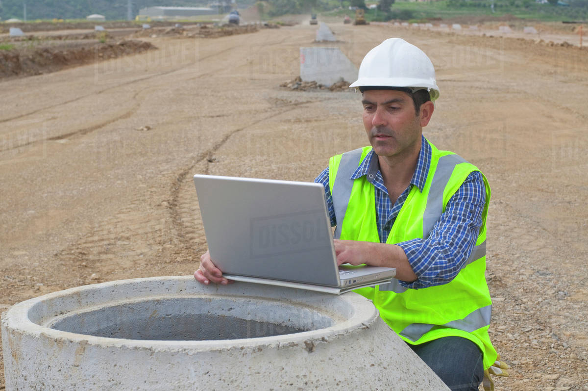 Hispanic construction worker using laptop in field - Royalty-free Stock ...