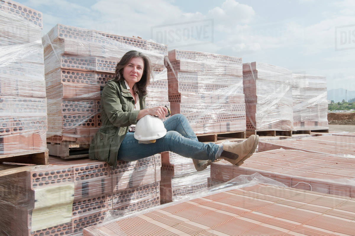 Caucasian construction worker sitting on stack of bricks - Royalty-free ...