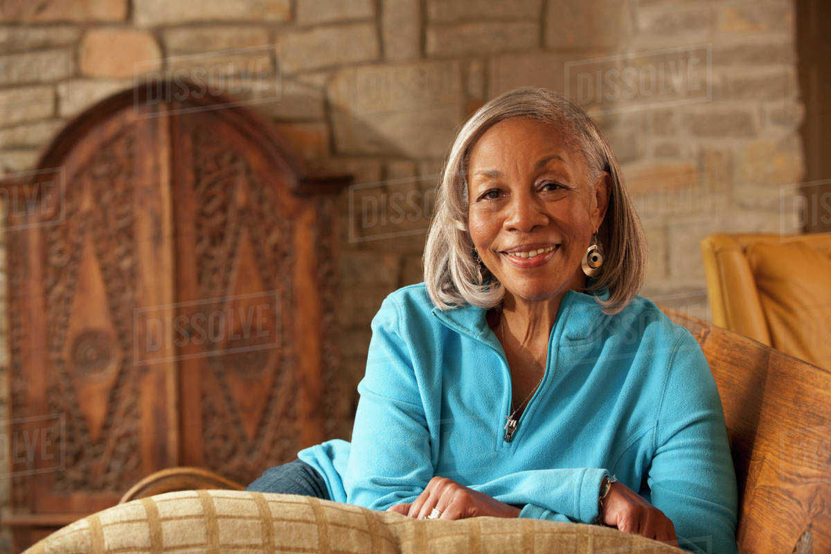 Black woman sitting on sofa - Royalty-free Stock Photo | Dissolve