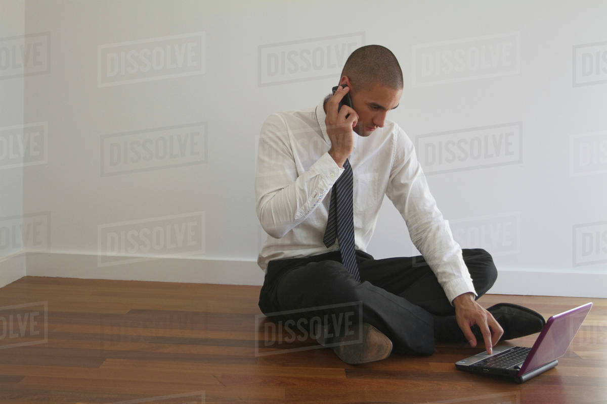Mixed race businessman using laptop on floor - Royalty-free Stock Photo ...