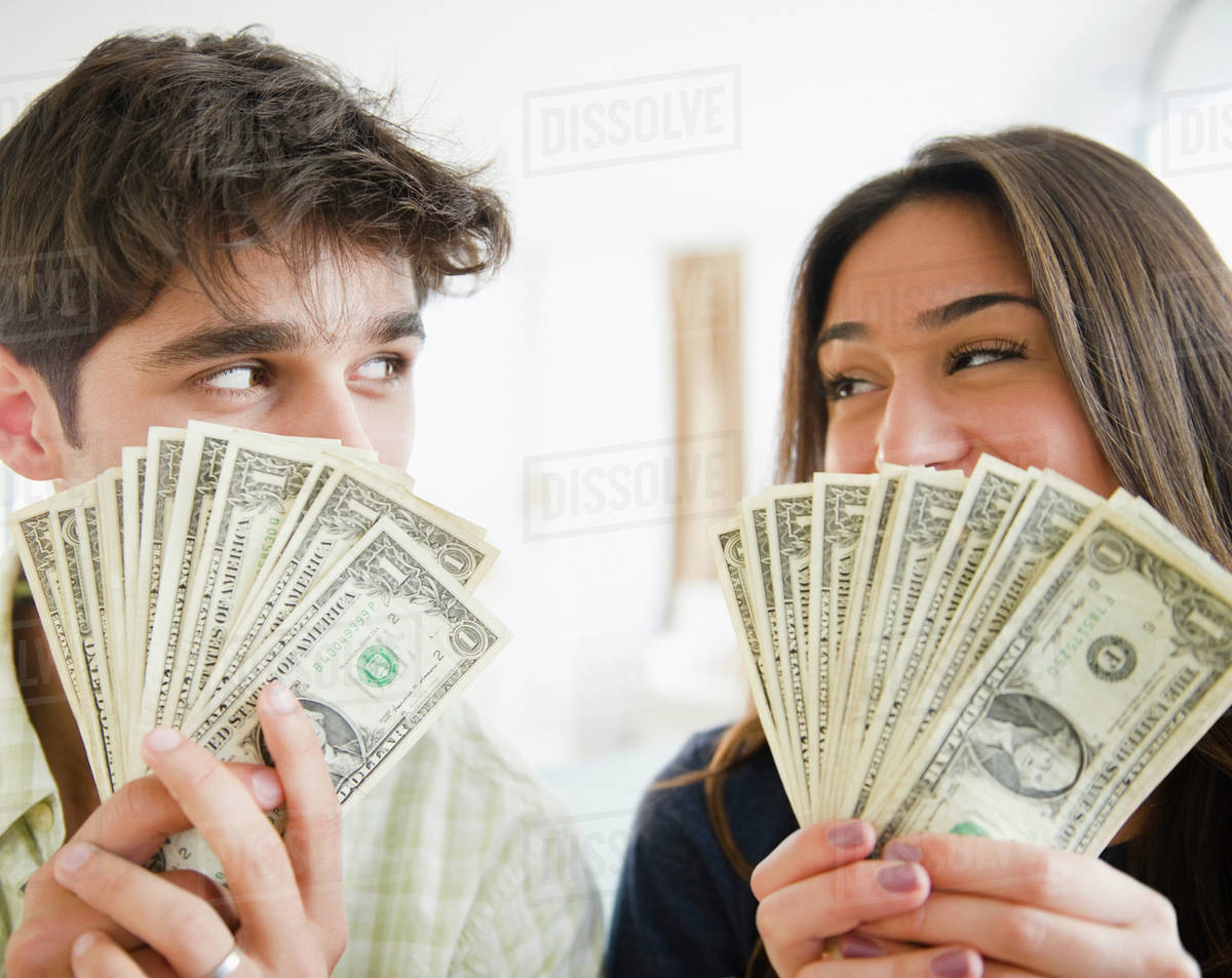 Couple holding handfuls of money - Royalty-free Stock Photo | Dissolve
