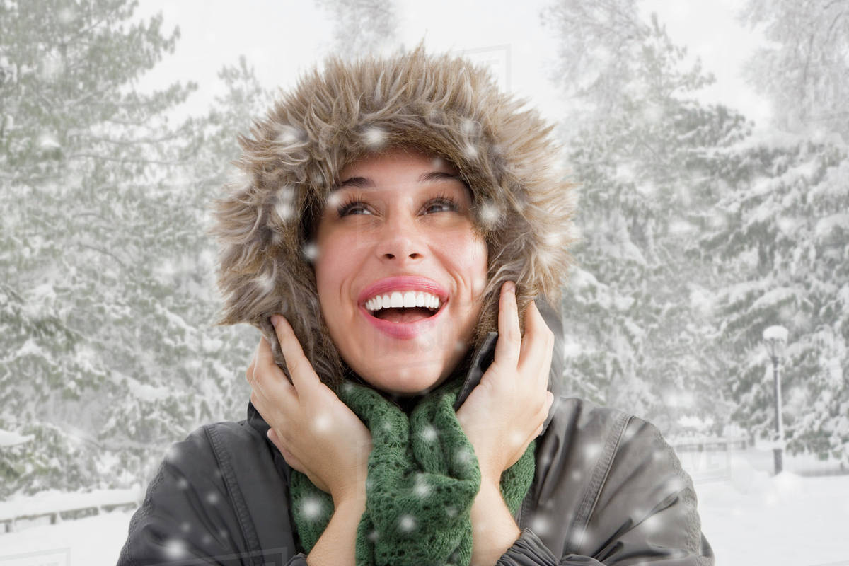 Mixed race woman in fur hood watching snow fall - Royalty-free Stock ...