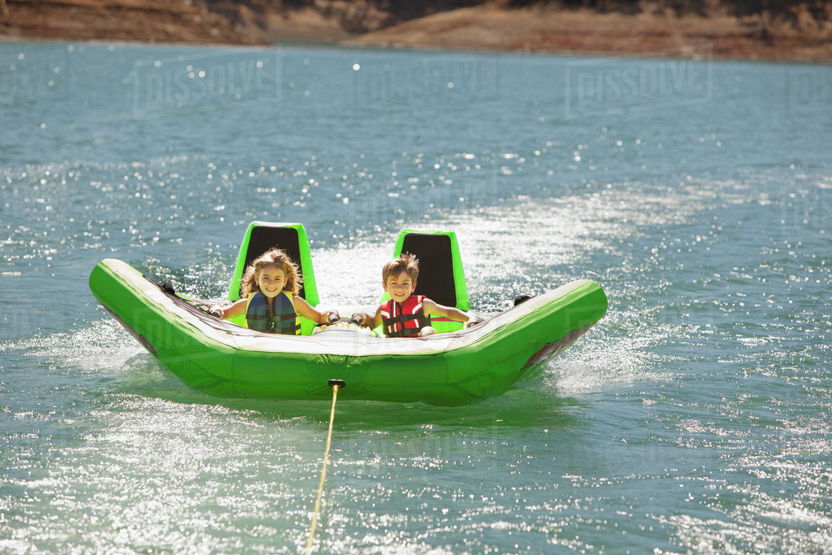 Children riding inflatable raft on lake - Royalty-free Stock Photo ...