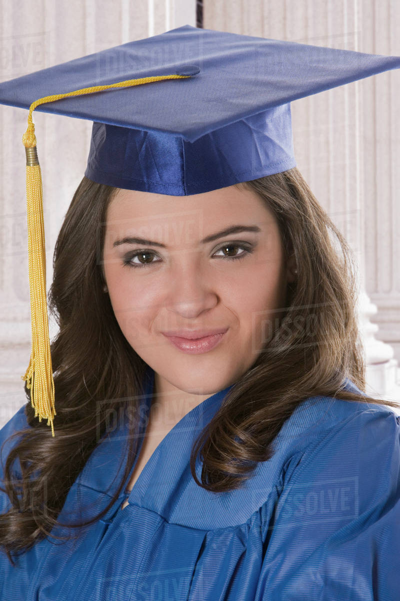 Hispanic teenage girl in graduation cap and gown - Stock Photo - Dissolve