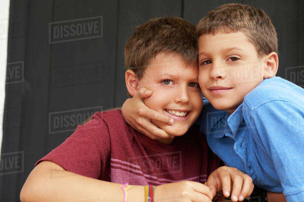 Smiling Hispanic boys hugging - Stock Photo - Dissolve
