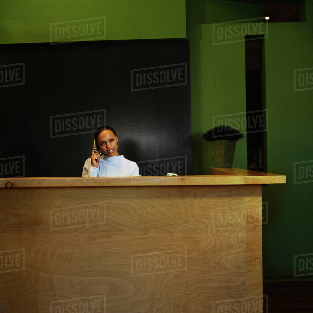 Woman working at reception desk in office - Royalty-free Stock Photo ...
