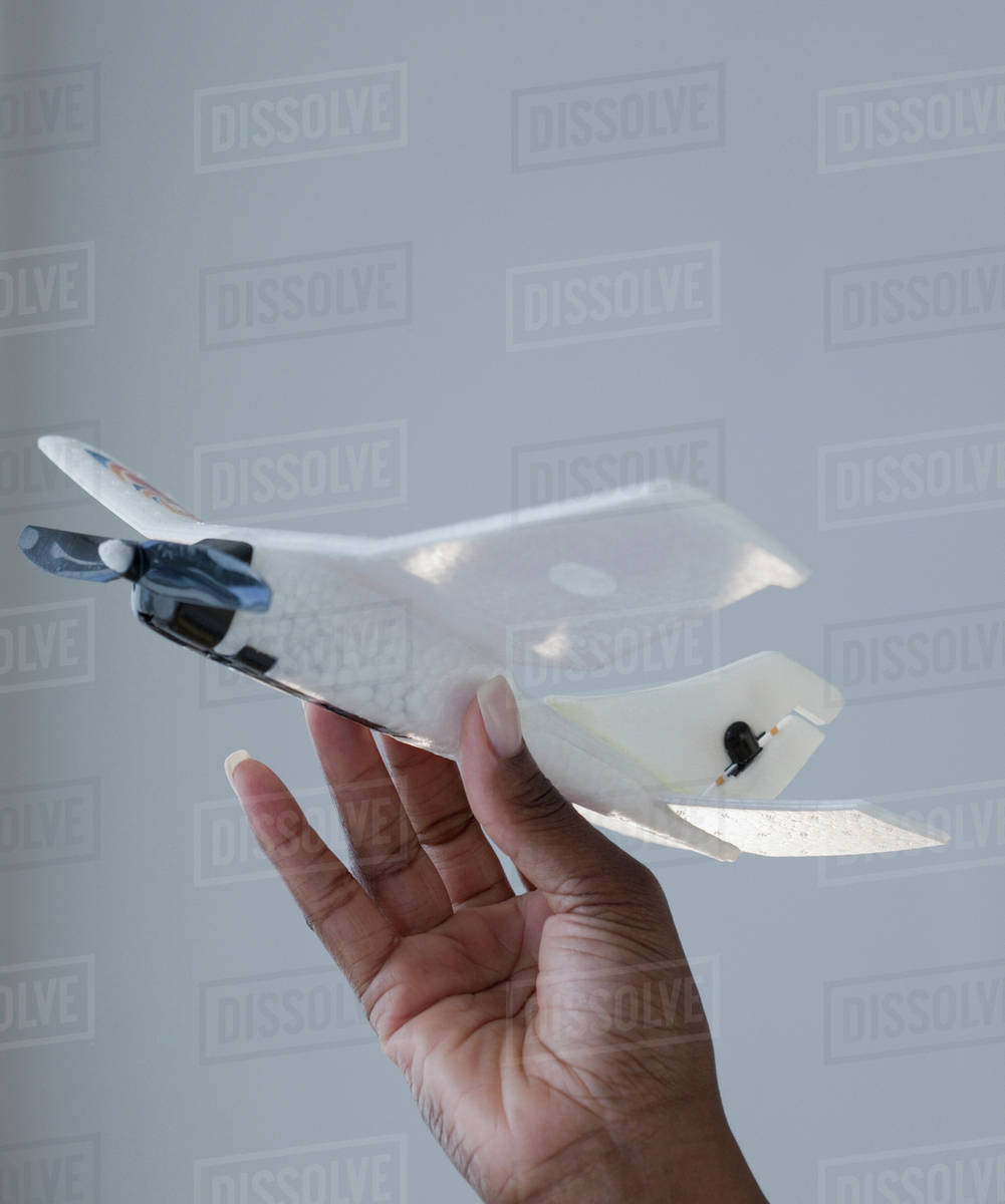 African woman holding airplane model - Royalty-free Stock Photo | Dissolve