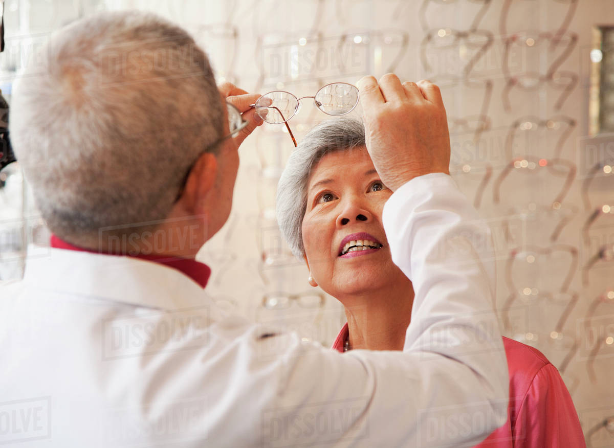 Chinese optician fitting woman's eyeglasses - Royalty-free Stock Photo ...