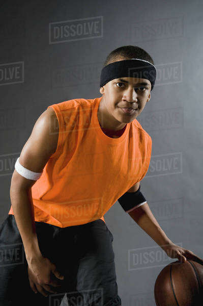 Mixed race basketball player dribbling basketball - Stock Photo - Dissolve