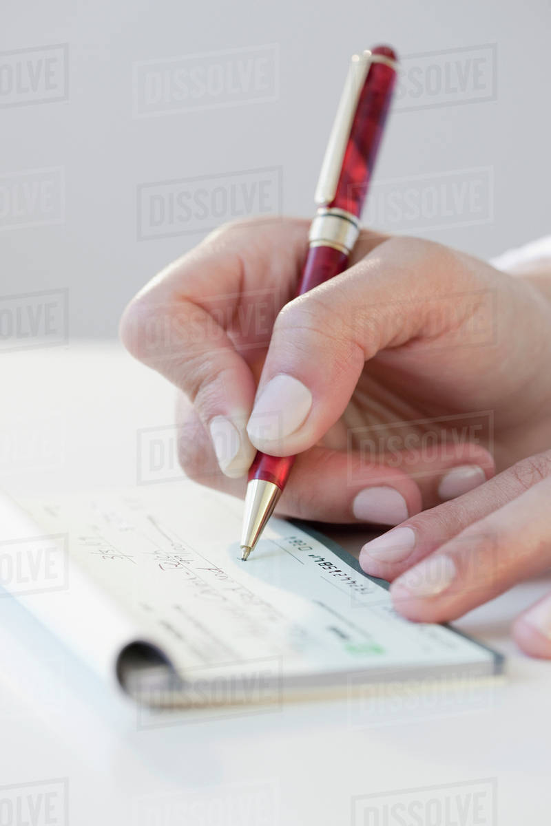 Woman writing personal check - Royalty-free Stock Photo | Dissolve