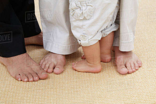 Close up of Hispanic family's feet - Stock Photo - Dissolve