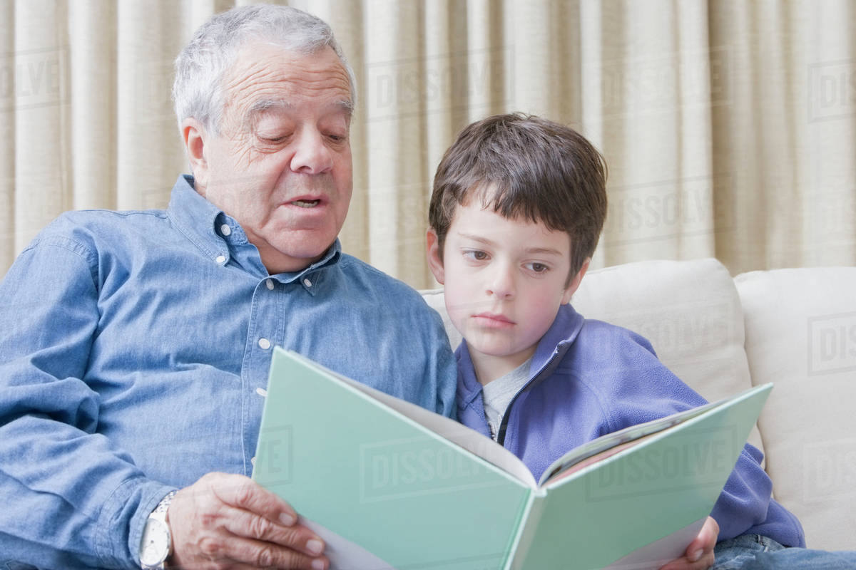 Hispanic grandfather reading book to grandson - Royalty-free Stock ...