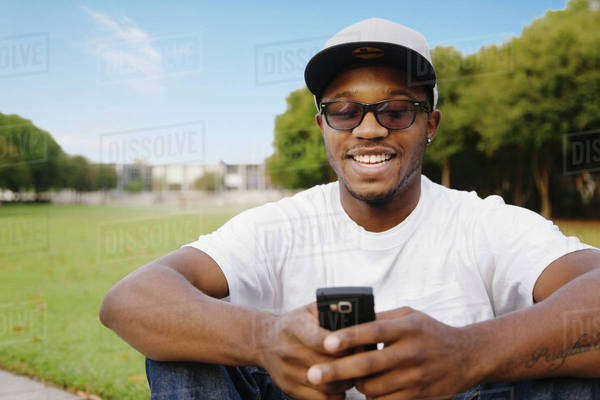African American man in park using cell phone - Royalty-free Stock ...