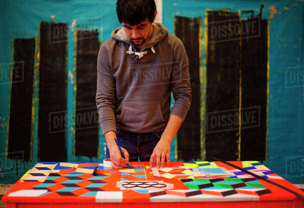 Mari man drawing on colorful table - Stock Photo - Dissolve