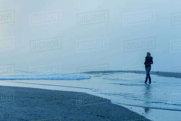 Caucasian woman walking in waves on beach - Royalty-free Stock Photo ...