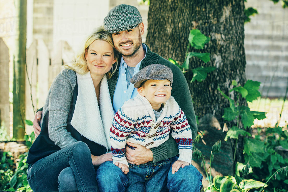Caucasian family smiling under tree - Royalty-free Stock Photo | Dissolve