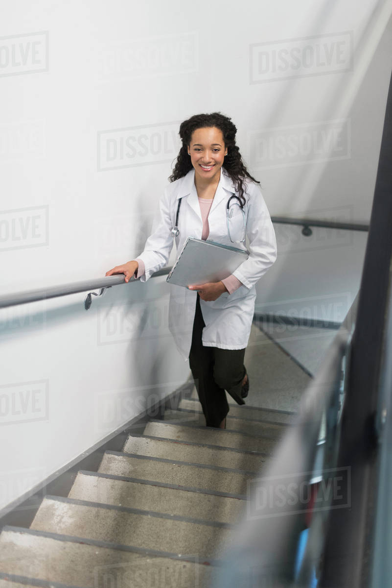 High angle view of mixed race doctor climbing staircase - Royalty-free ...
